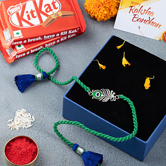 Buy/Send Silver Morpankh Krishna Rakhi N Kitkat Chocolate Combo Online- FNP